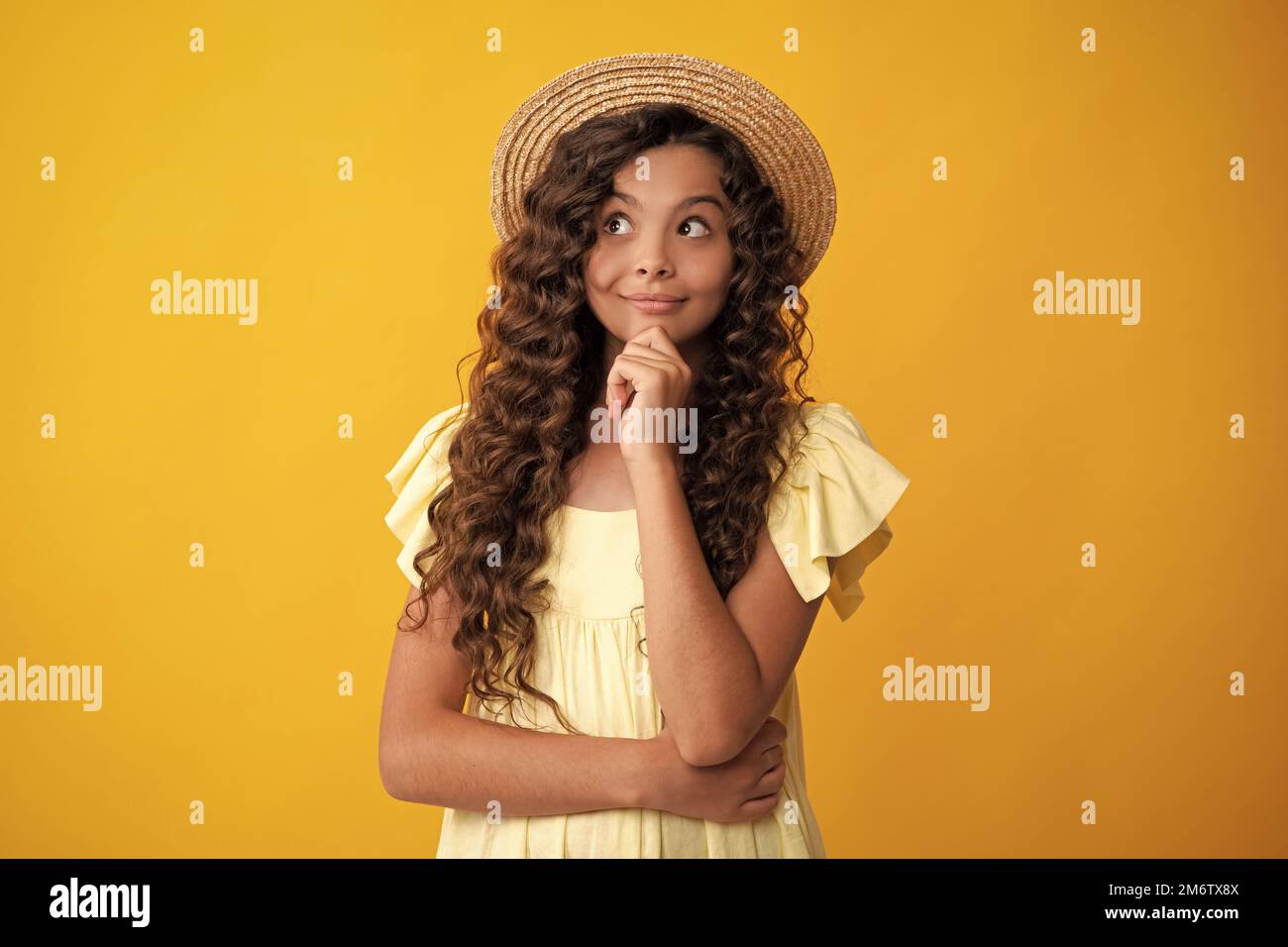 Thoughtful teenage child girl on yellow background. Portrait of a kid ...