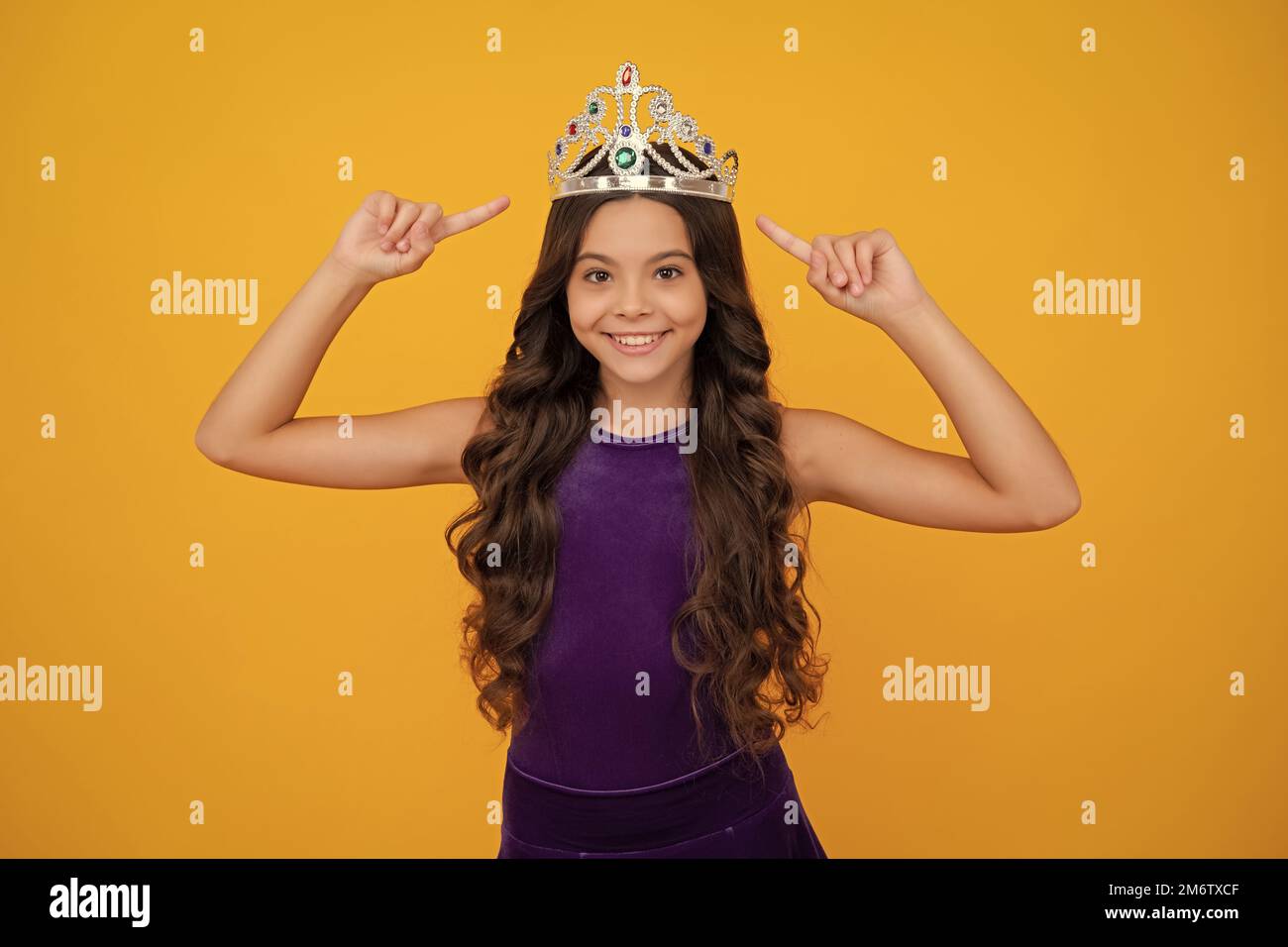 Teen child in queen crown isolated on yellow background. Princess girl ...