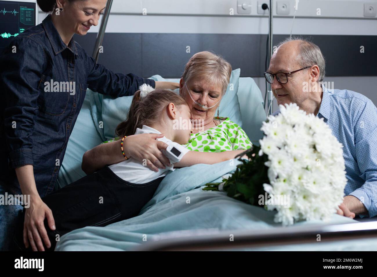 Little granddaughter giving flowers bouquet to sick grandmother. Old ...