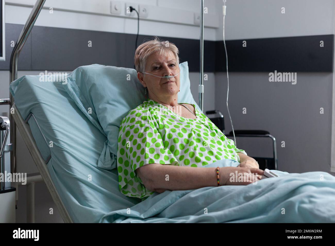 Terminally ill woman resting at hospital bed with breathing medical ...