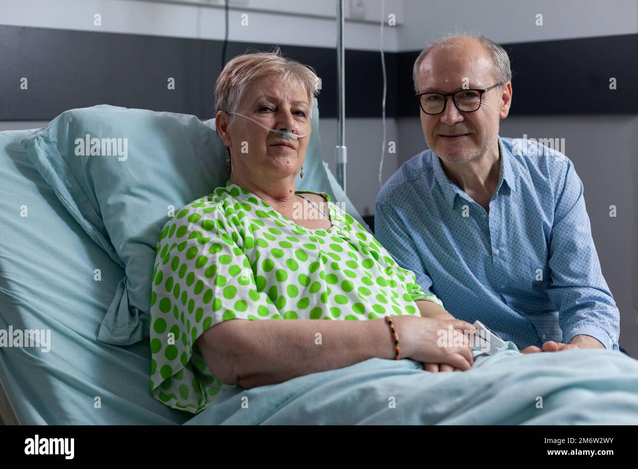 Elderly woman recovering from surgery with brother in hospital room ...