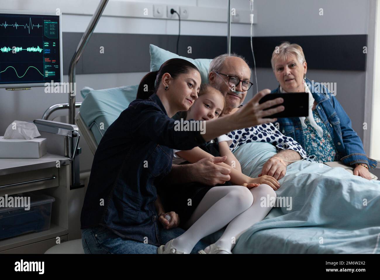 Sick citizen adult daughter taking cell phone self portrait with family ...