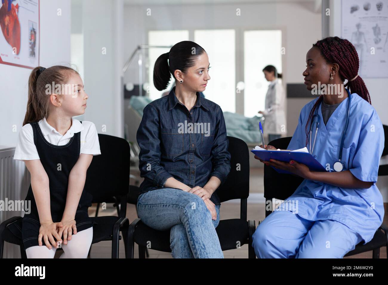 African american doctor explaining daughter health status to young ...