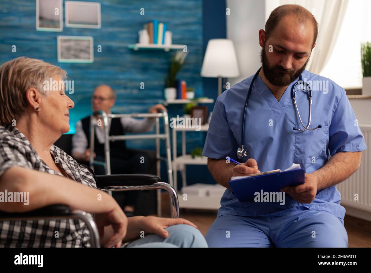 Male medical assistant wearing uniform and stethoscope filling out ...