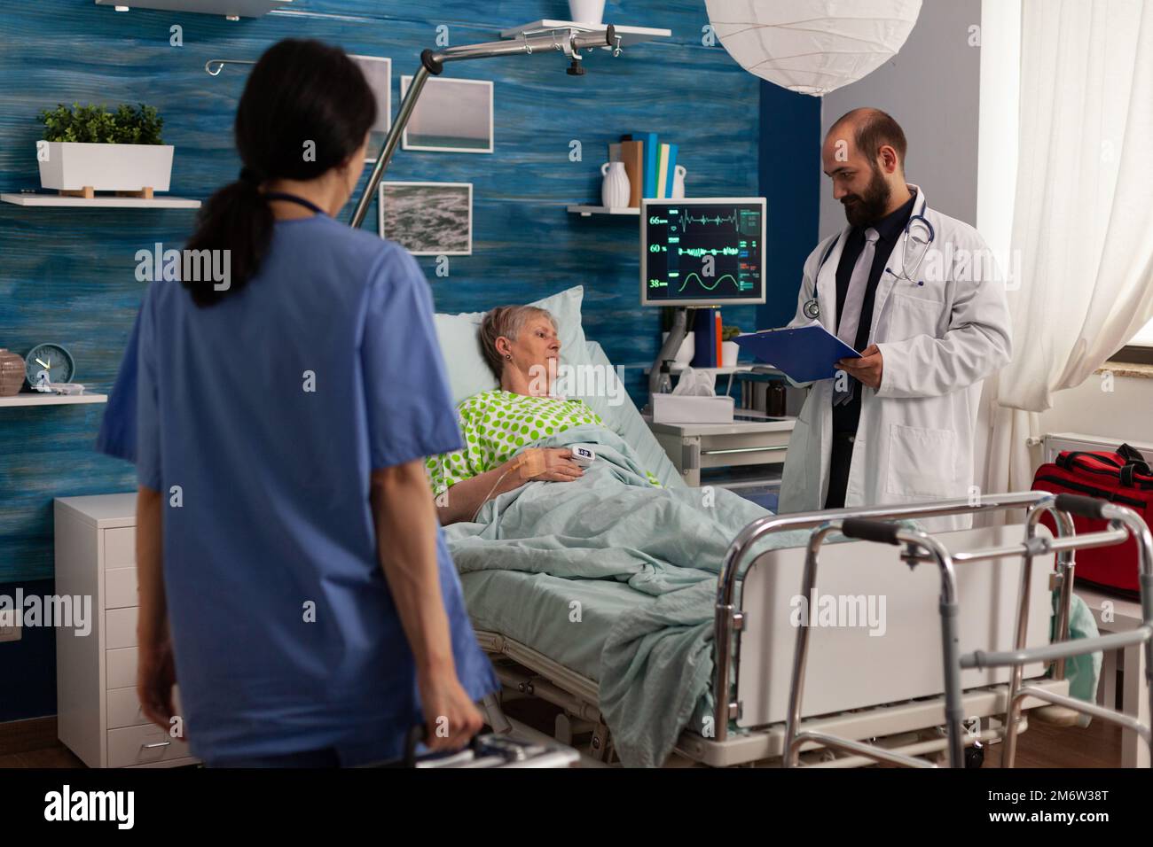 Doctor assisting elderly female patient in health center room ...