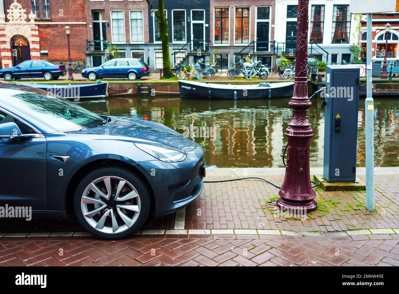AMSTERDAM, NETHERLANDS, electric car charging at a plug-in charging ...