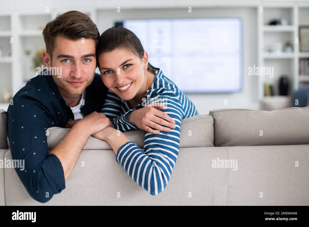Couple Watches TV together while Sitting on a Couch in the Living Room ...