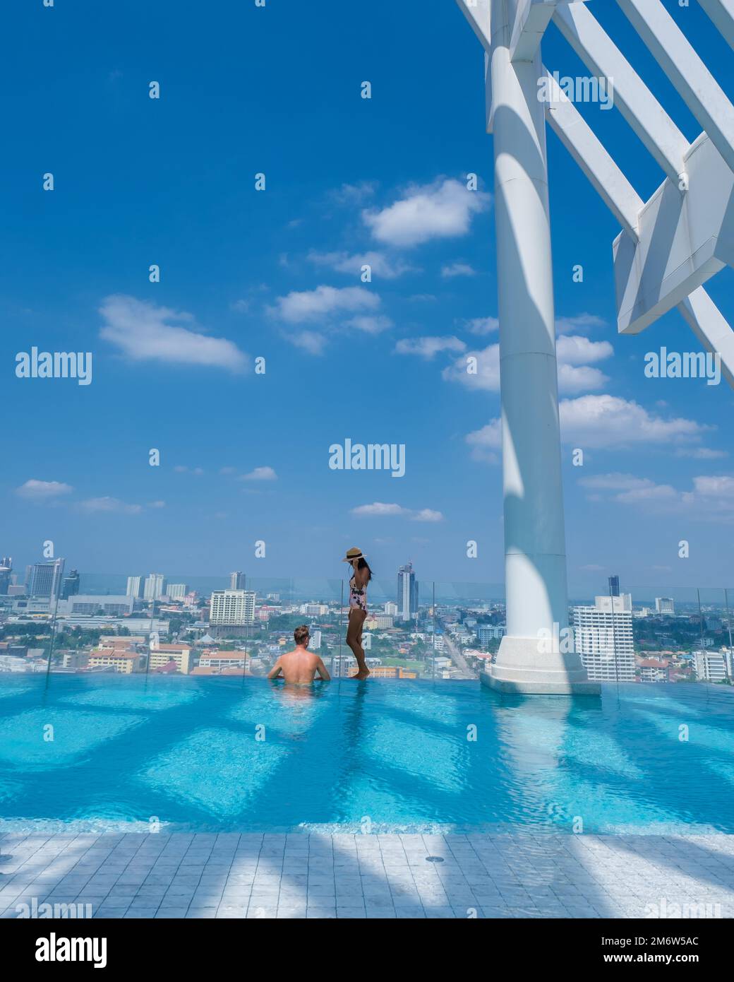 Couple men and women relaxing at a rooftop pool of a luxury hotel Stock Photo - Alamy