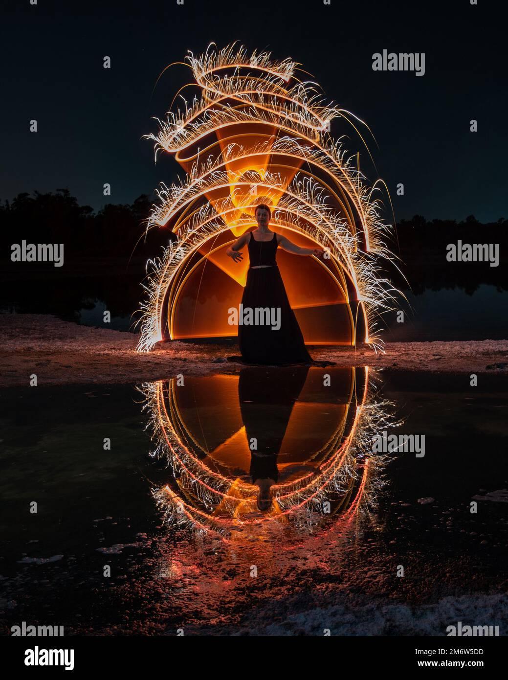 Woman posing for light painting with bright lights in the dark ...