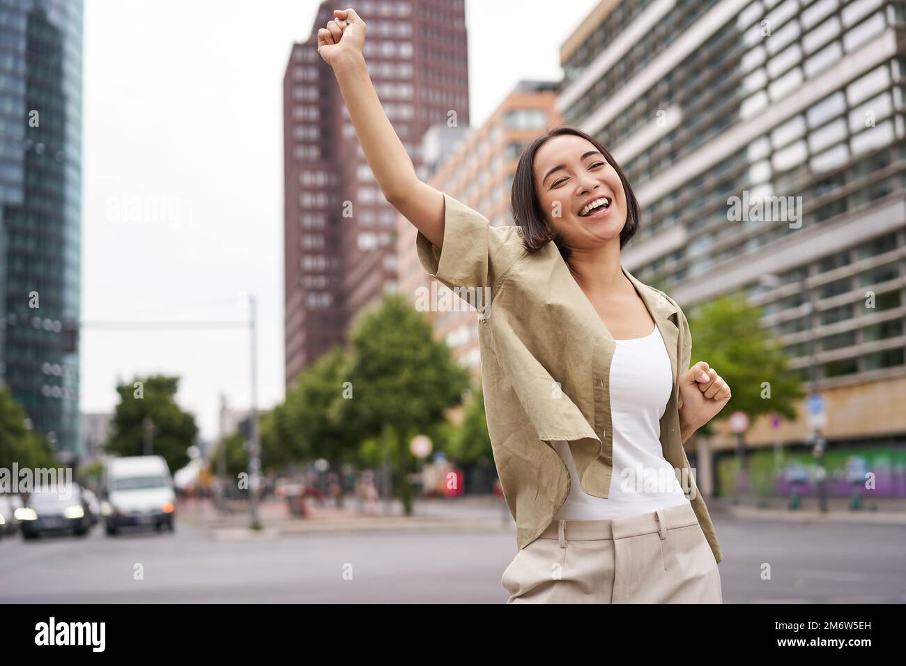 Portrait of happy asian woman, dancing and feeling joy, triumphing ...