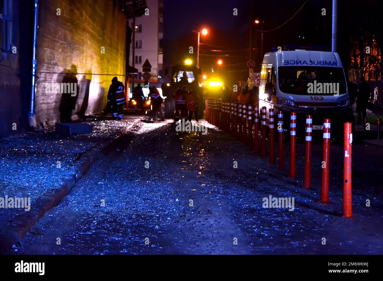 workers clear the street from glass pieces near destroyed residential ...