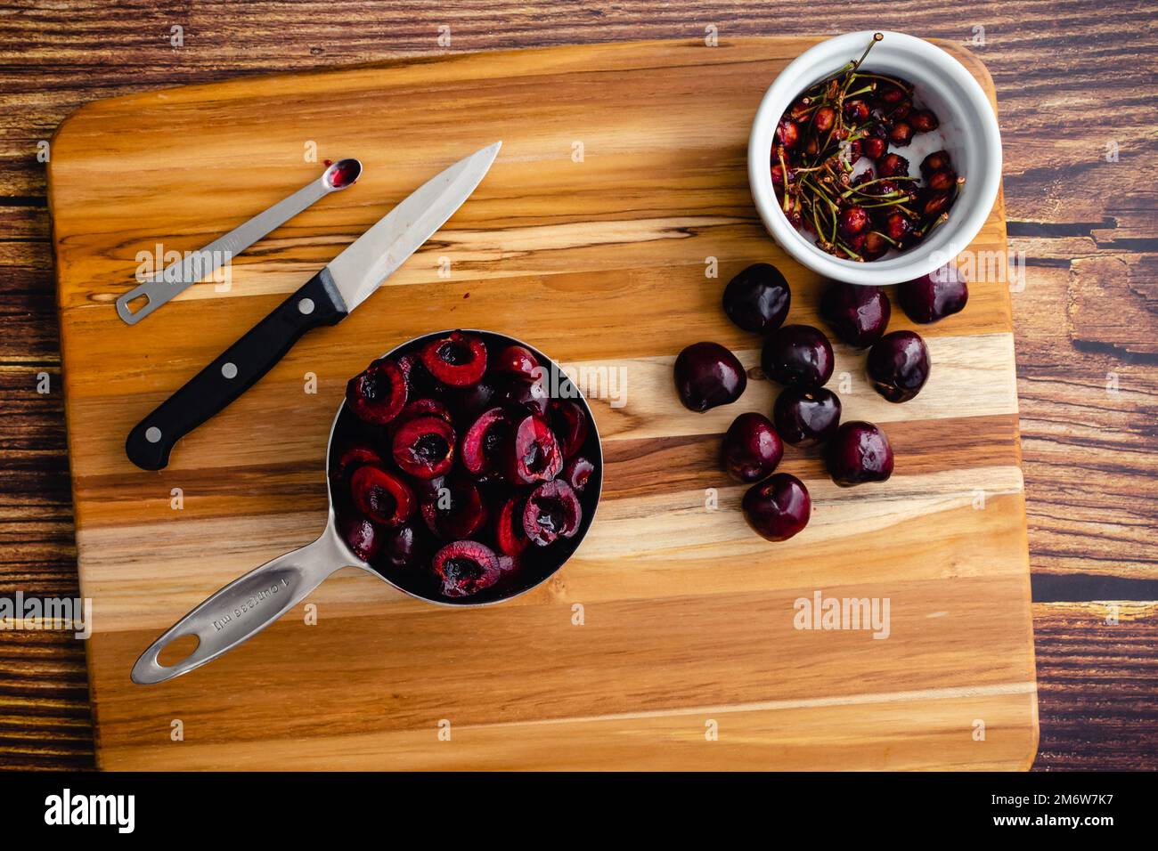 Halved and Pitted Cherries on a Wood Cutting Board: Raw cherries with ...