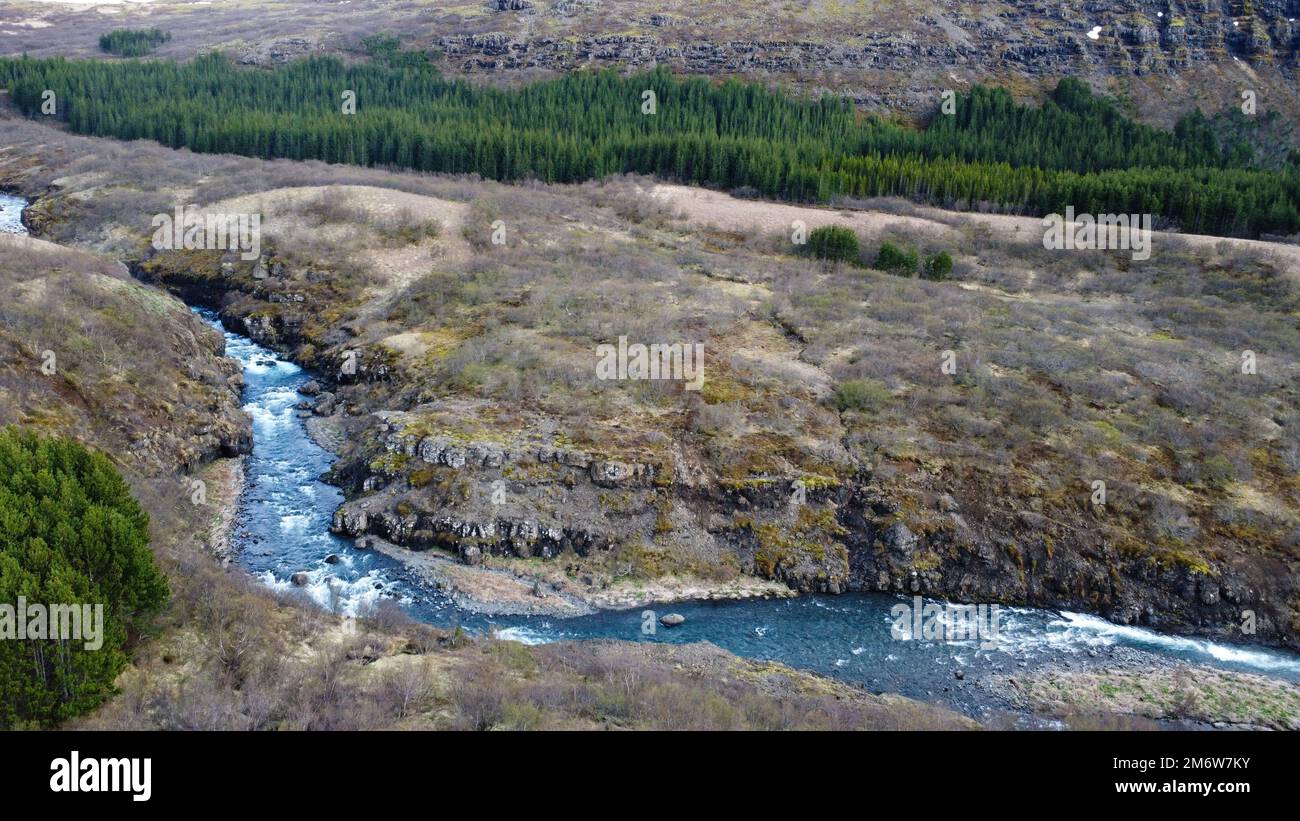 An aerial view of a river flowing downstream in the middle of cliffs ...