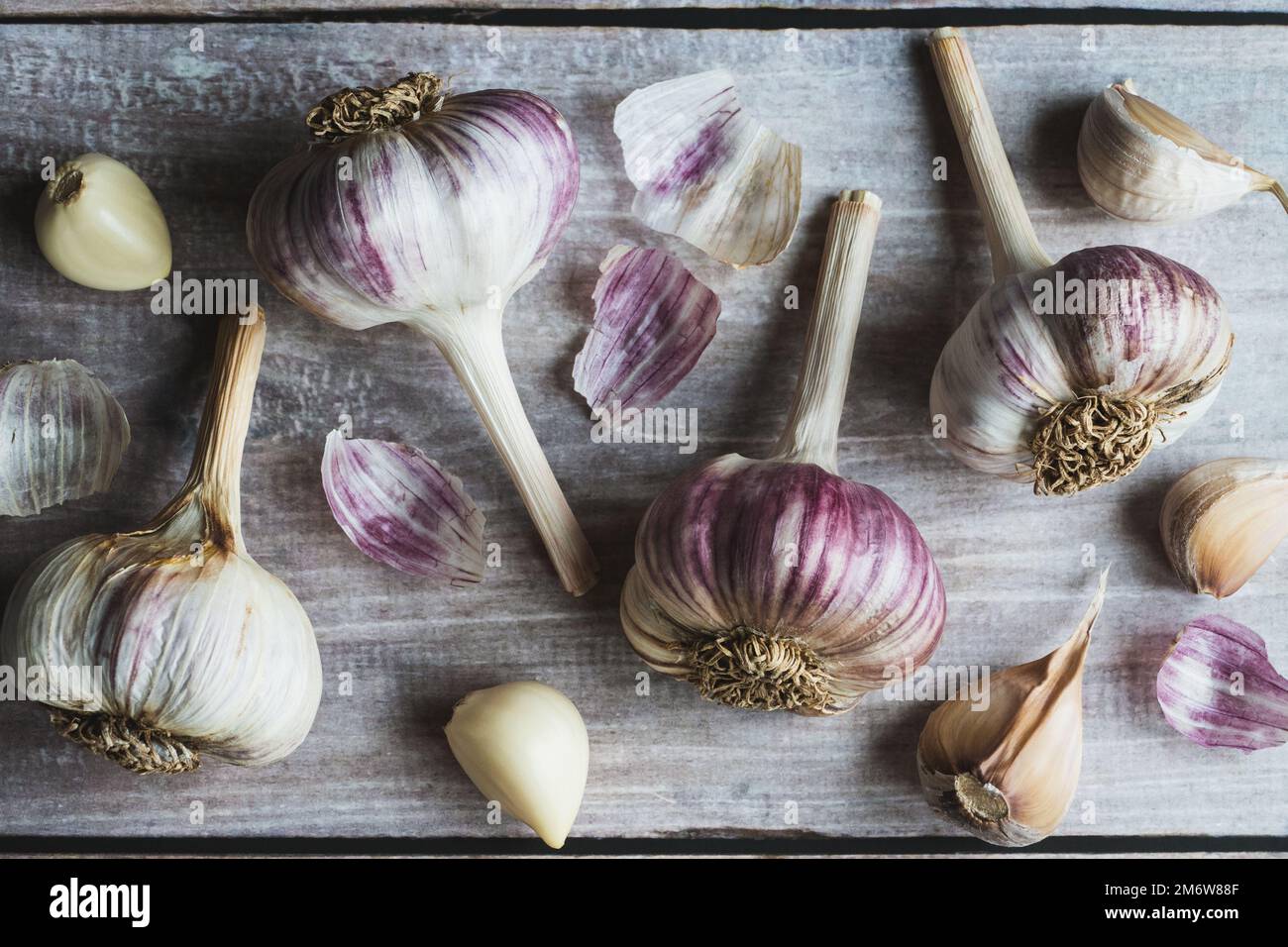 Garlic on wooden table, garlic bulbs and cloves food background, flat ...