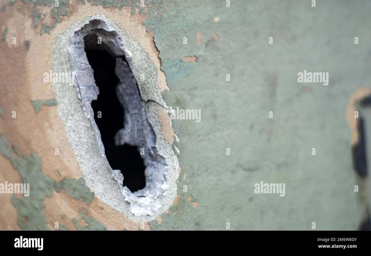 Hole or hole, armor deformation from a projectile close-up. Damaged ...