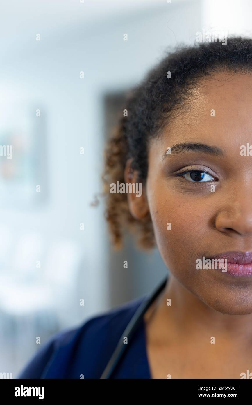 Vertical half face portrait of african american female doctor in ...