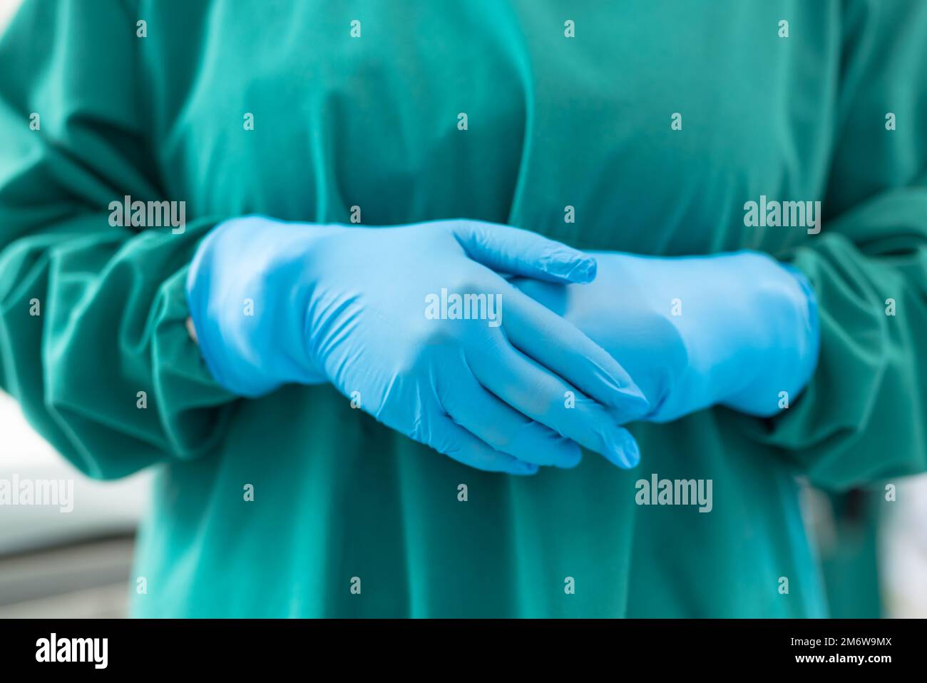 Midsection of female surgeon ready for operation in blue surgical ...