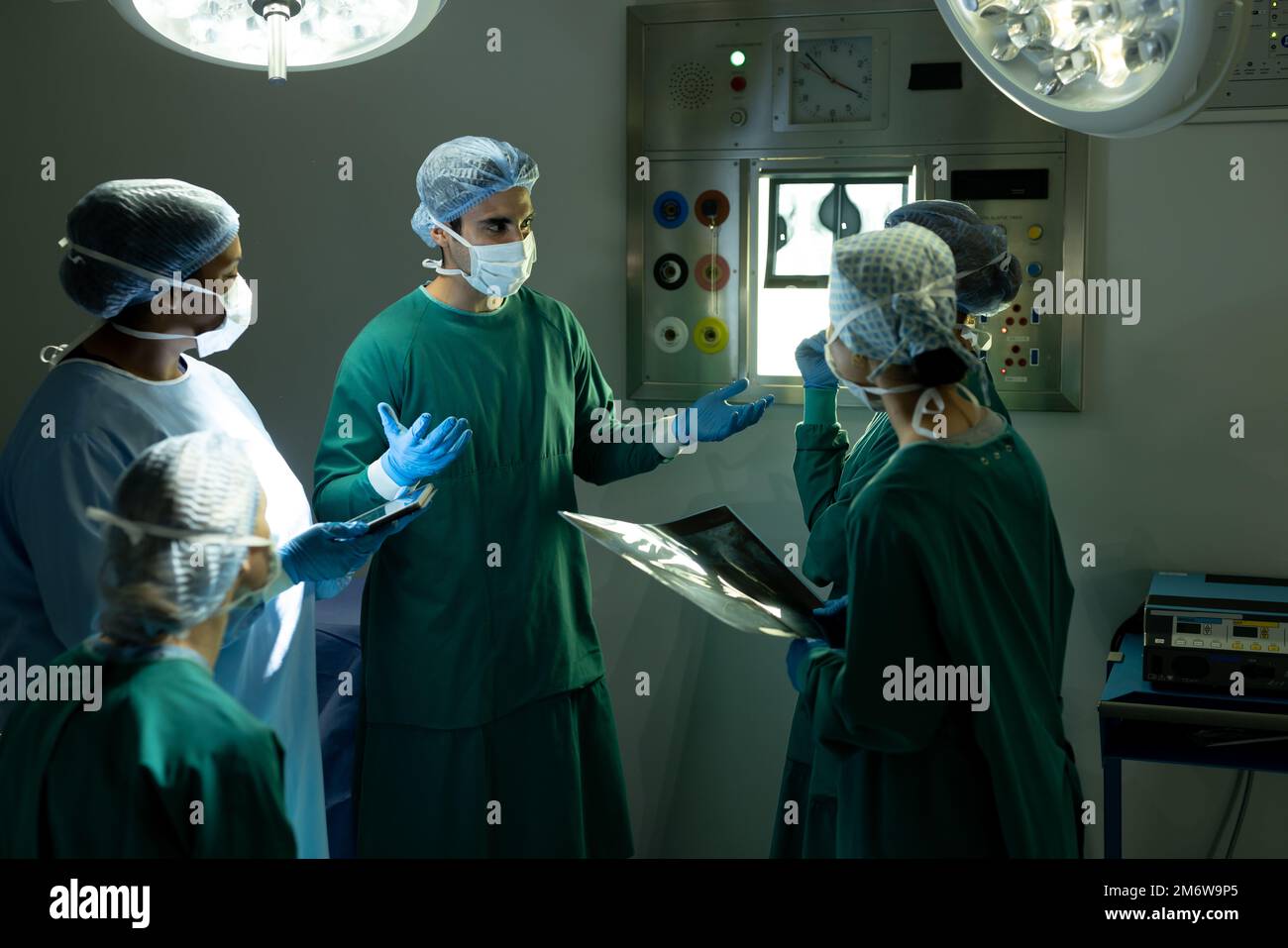 Diverse group of male and female surgeons in discussion, in operating ...
