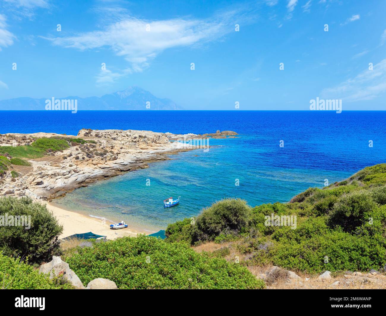 Boat near single camping tent on summer stony sea coast with Atthos ...