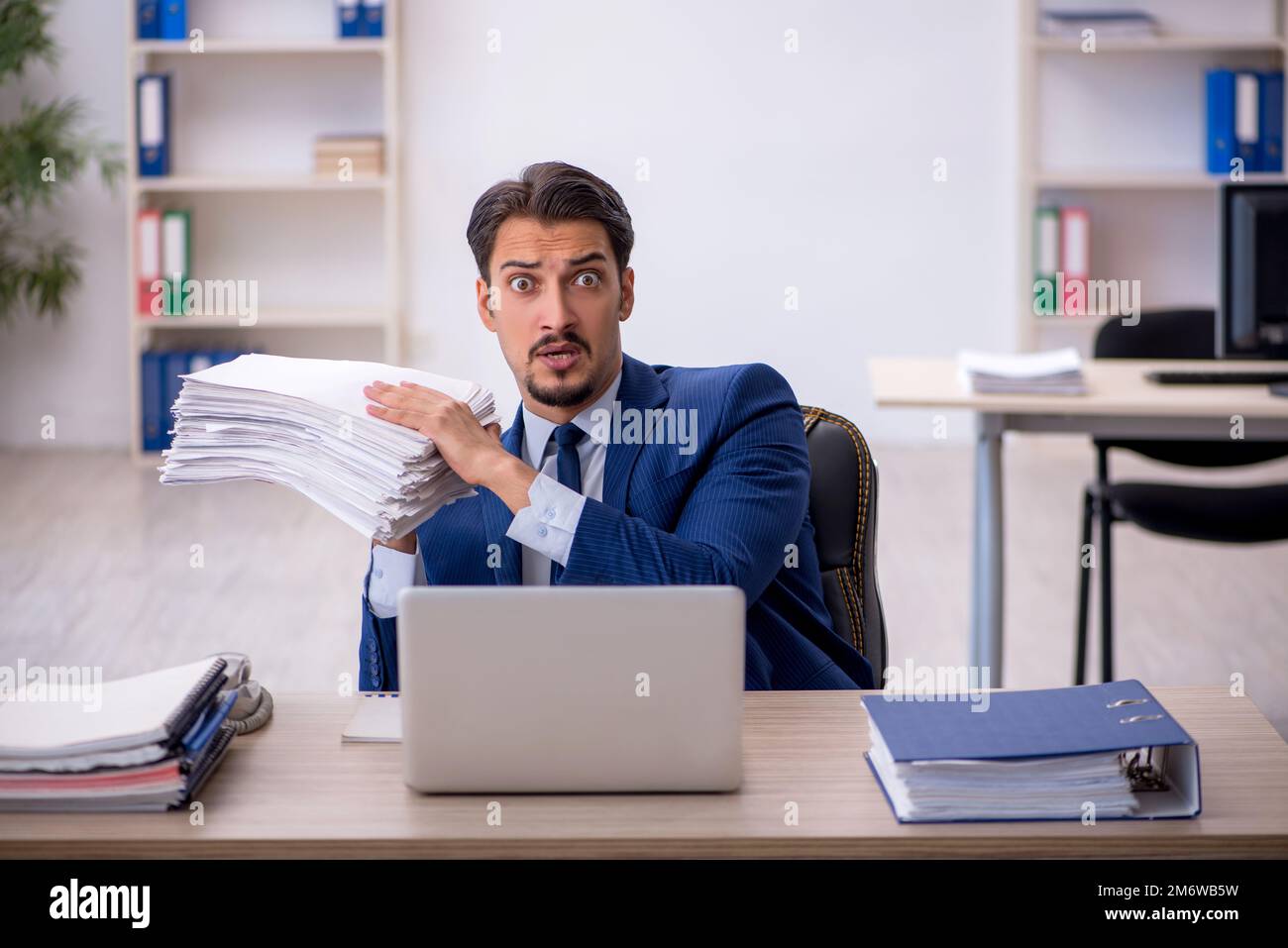 Young male employee working in the office Stock Photo - Alamy