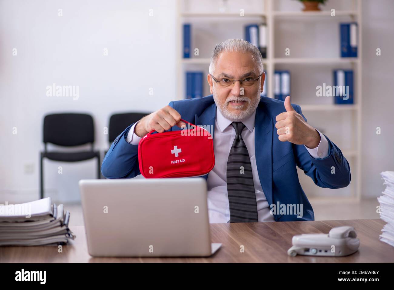 Old male employee feeling bad at workplace Stock Photo - Alamy