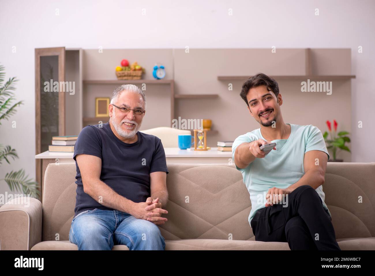 Father and son watching tv during pandemic Stock Photo - Alamy