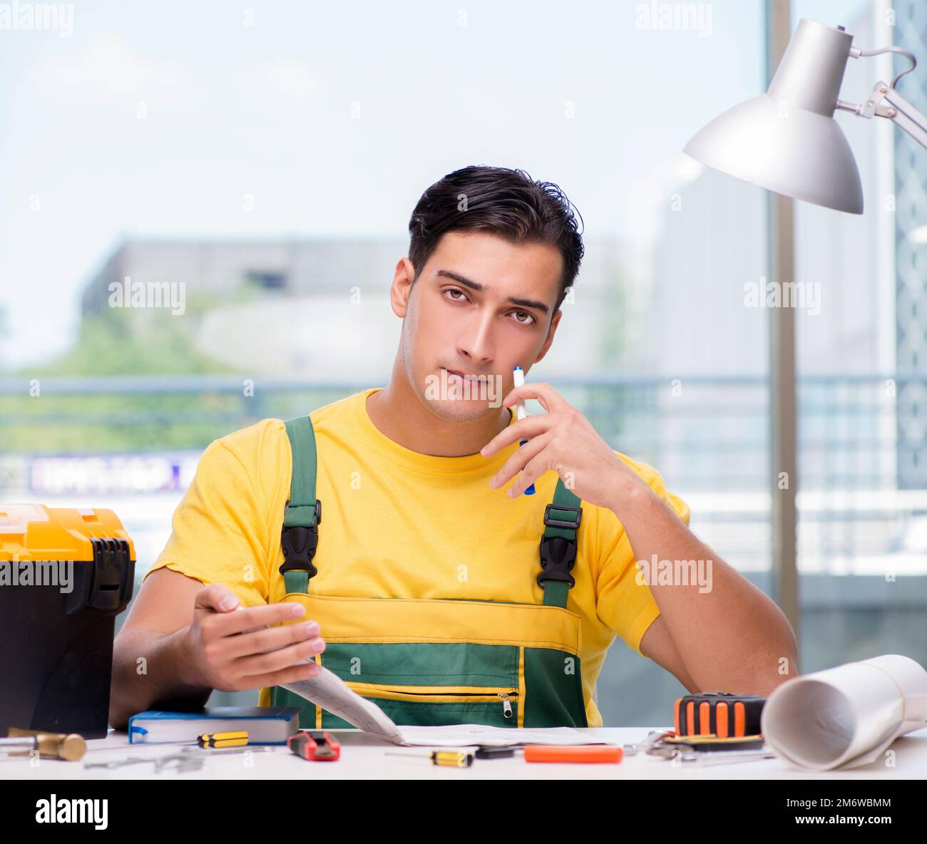 Construction worker sitting at the desk Stock Photo - Alamy