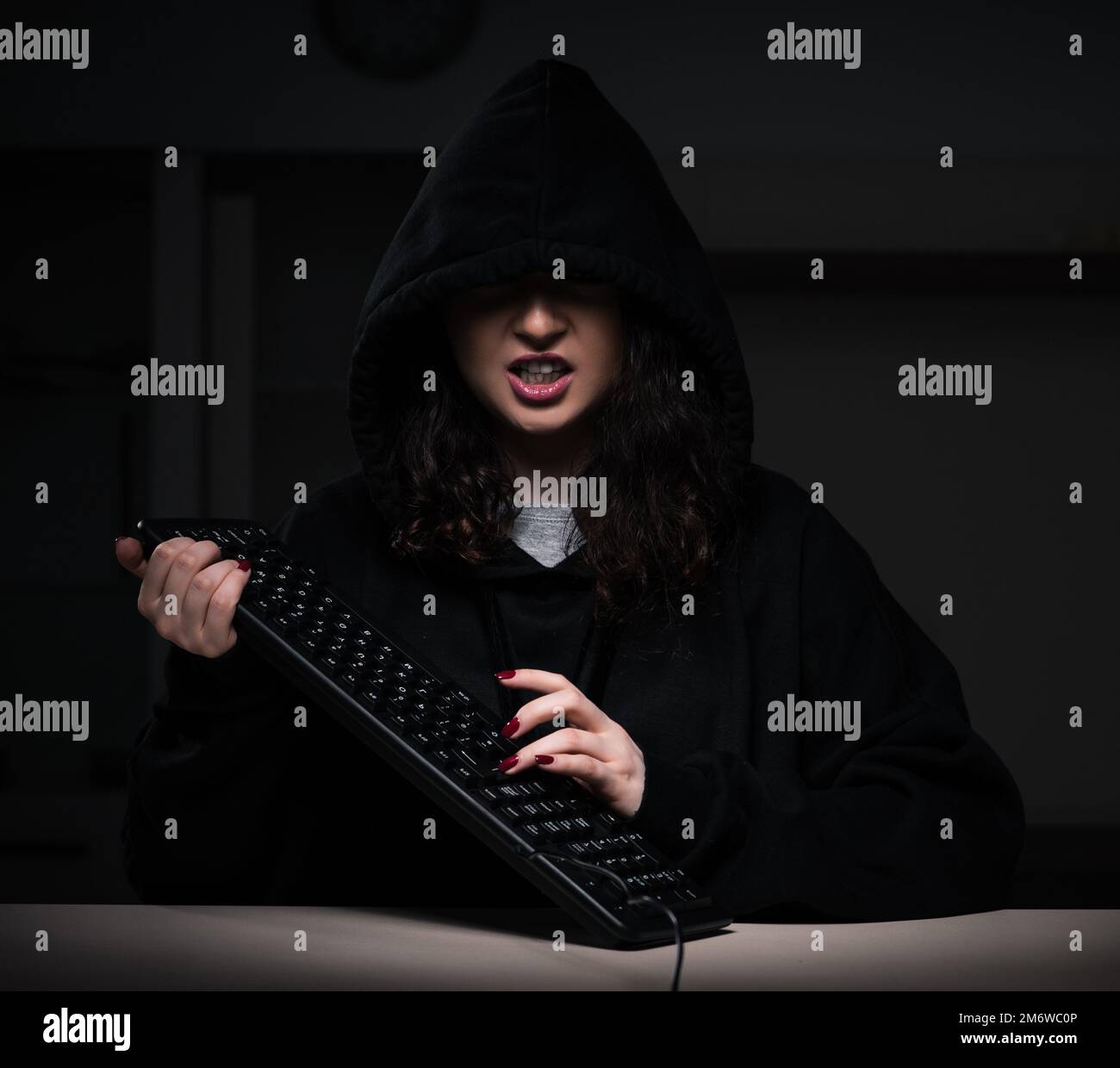 Female hacker hacking security firewall late in office Stock Photo - Alamy