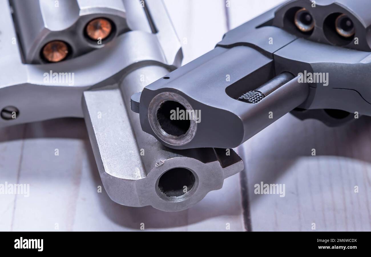 Two snub nose revolvers, a black 38 special and a stainless 357 magnum ...