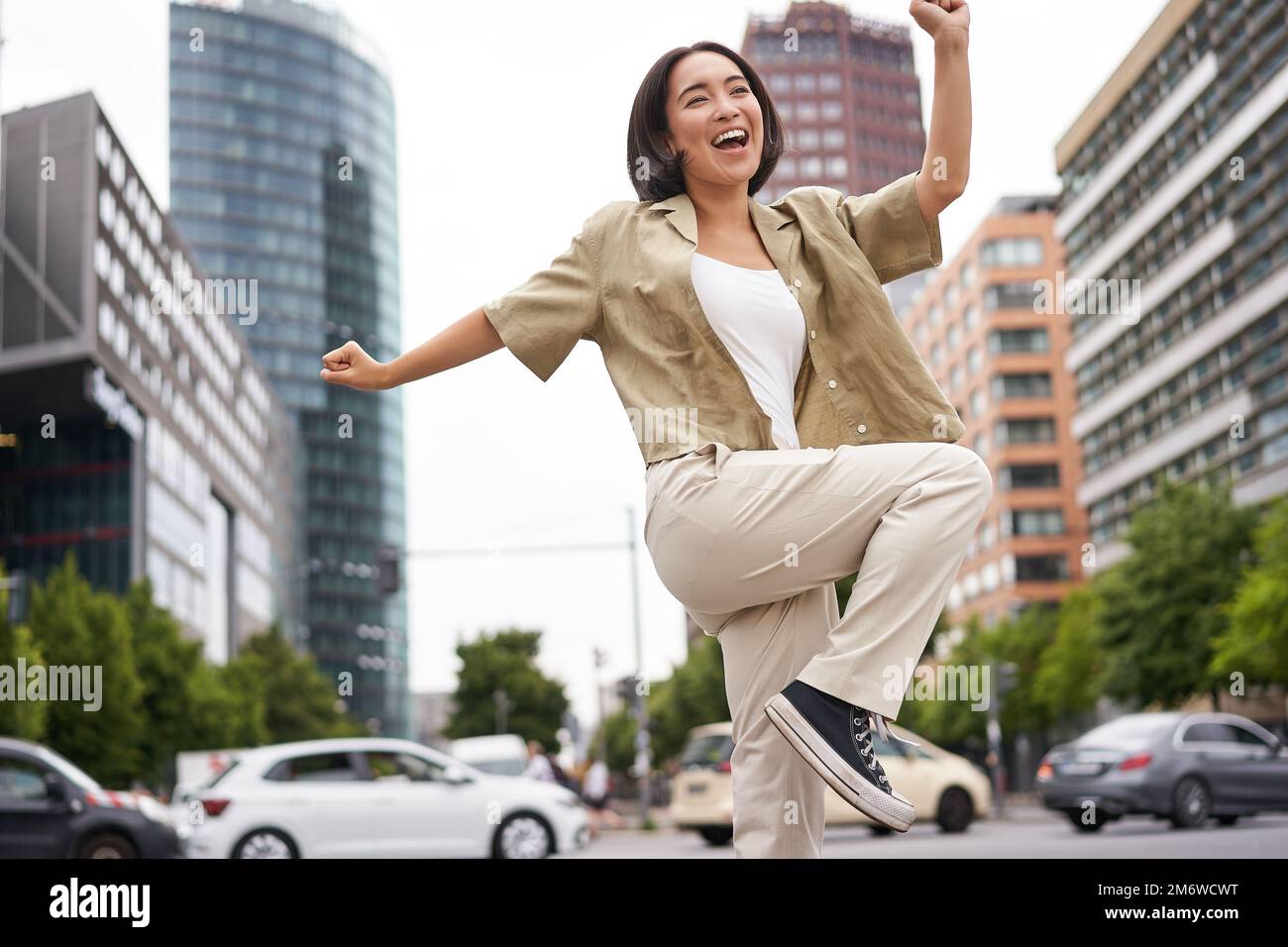 Portrait of dancing asian woman, raising hands up and feeling happy ...