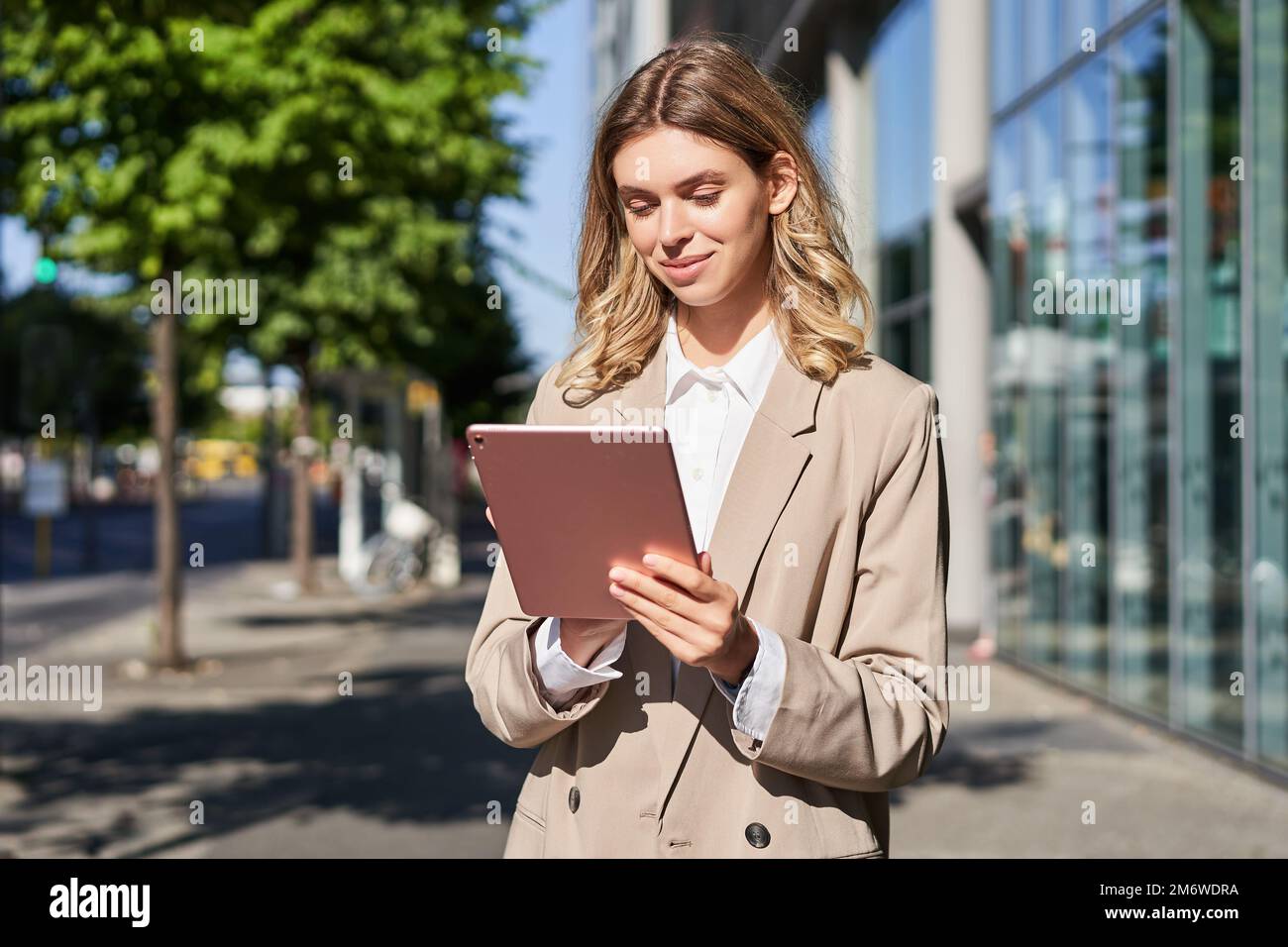 Portrait of corporate woman using her digital tablet, working and ...