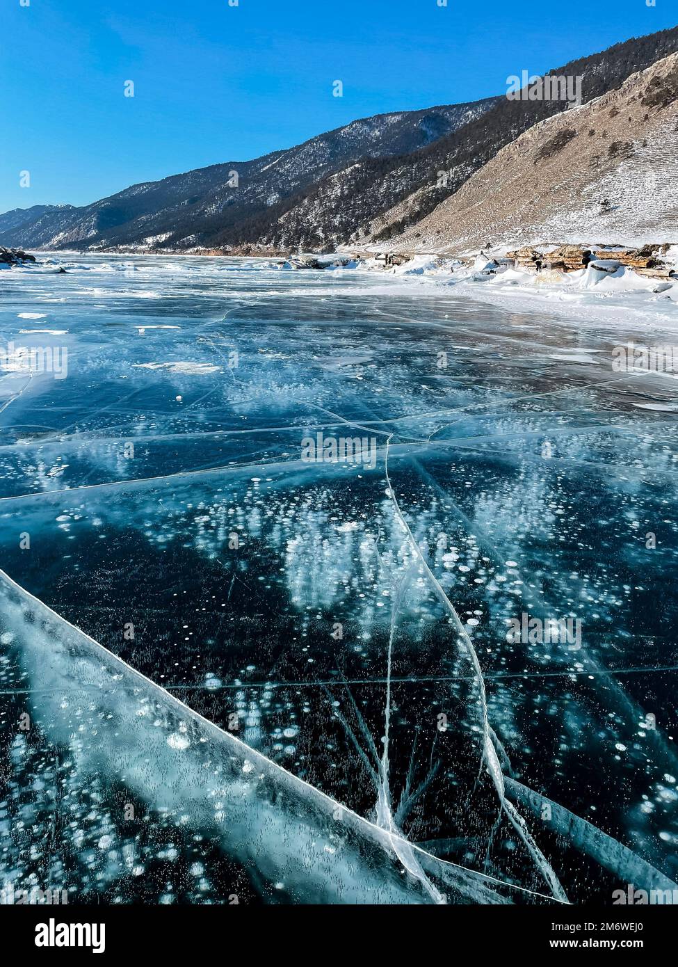 Texture of beautiful blue ice with cracks and air bubbles in the frozen ...