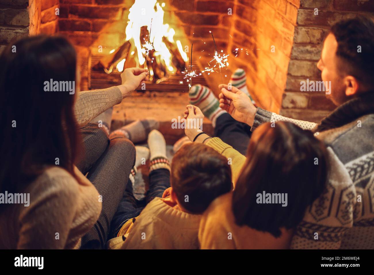 Happy young family parents with two small kids gathering around brick ...