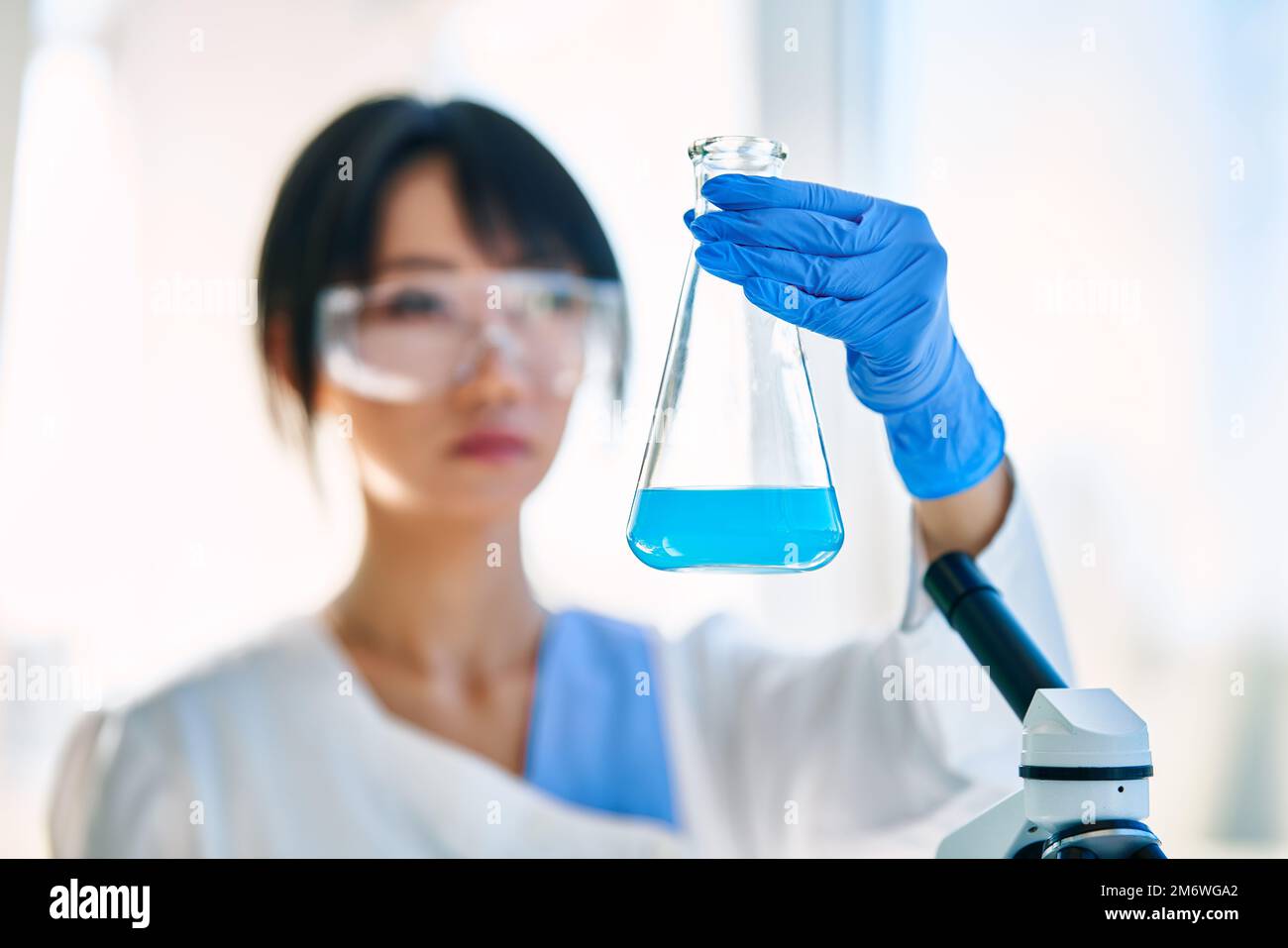Scientist holding flask working in chemical science laboratory Stock Photo - Alamy