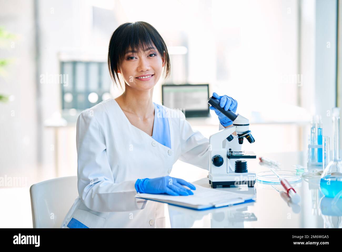Smiling asian female scientist posing in modern medical research ...