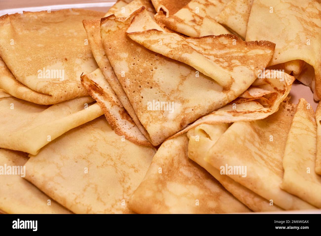 Blini (Russian crepes) served folded on a dish Stock Photo - Alamy