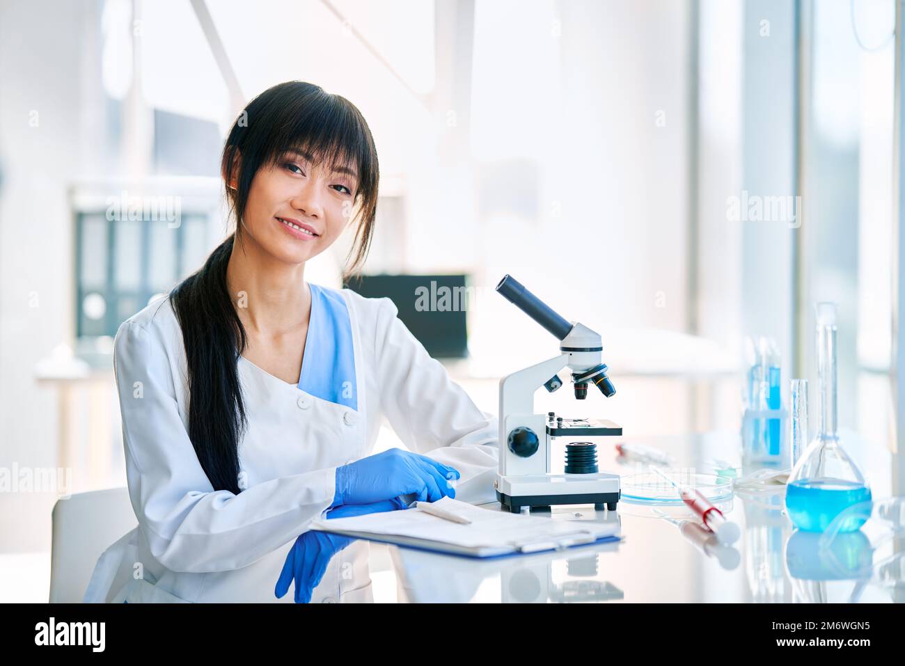 Smiling asian female scientist posing in modern medical research ...