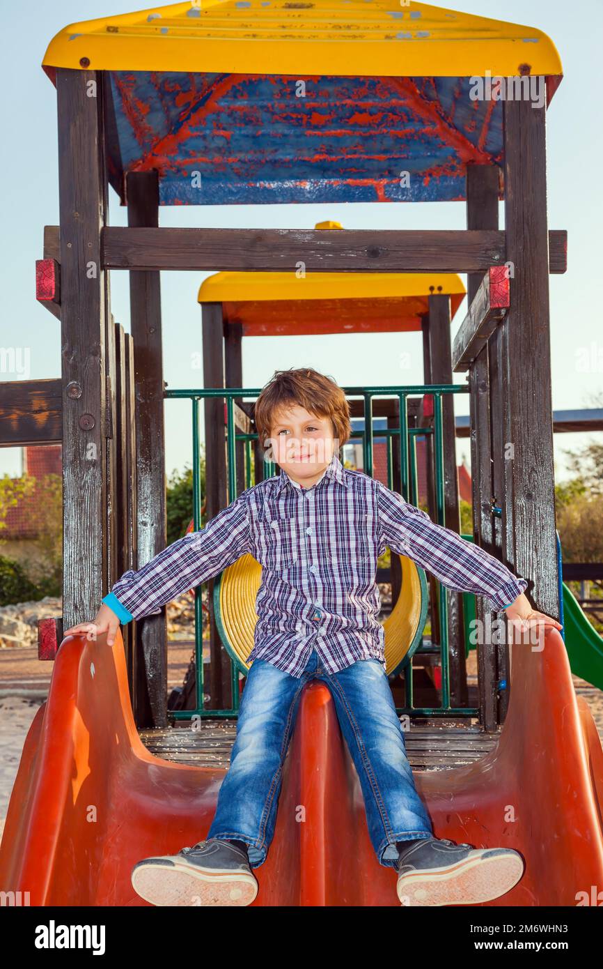 Charming boy in jeans plays on the playground Stock Photo - Alamy