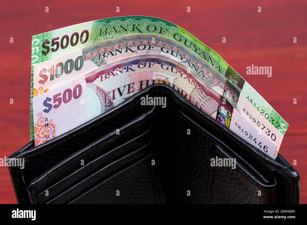Guyanese dollar in the black wallet Stock Photo - Alamy