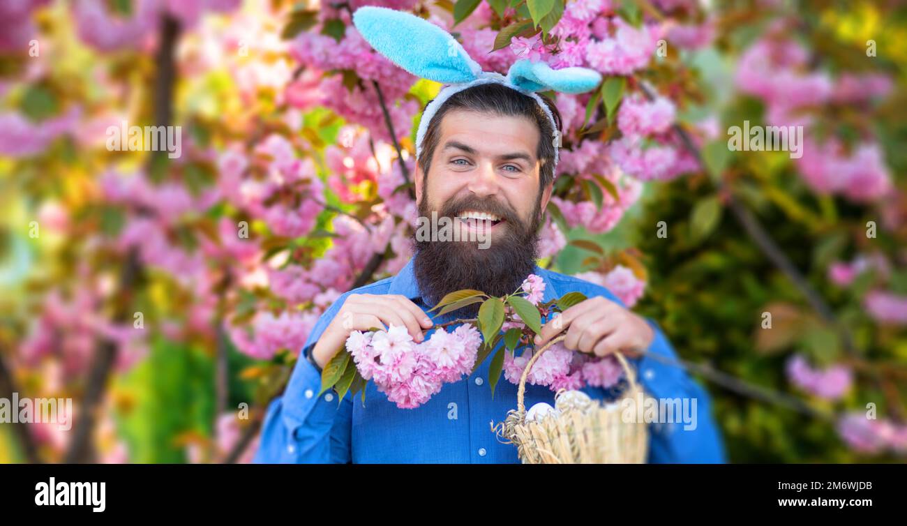Man preparation for Easter. Bearded man with easter eggs on sprig ...