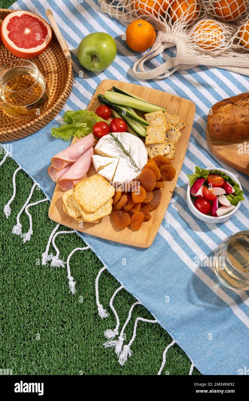 Picnic blanket with charcuterie boards, healthy food and wine in park ...