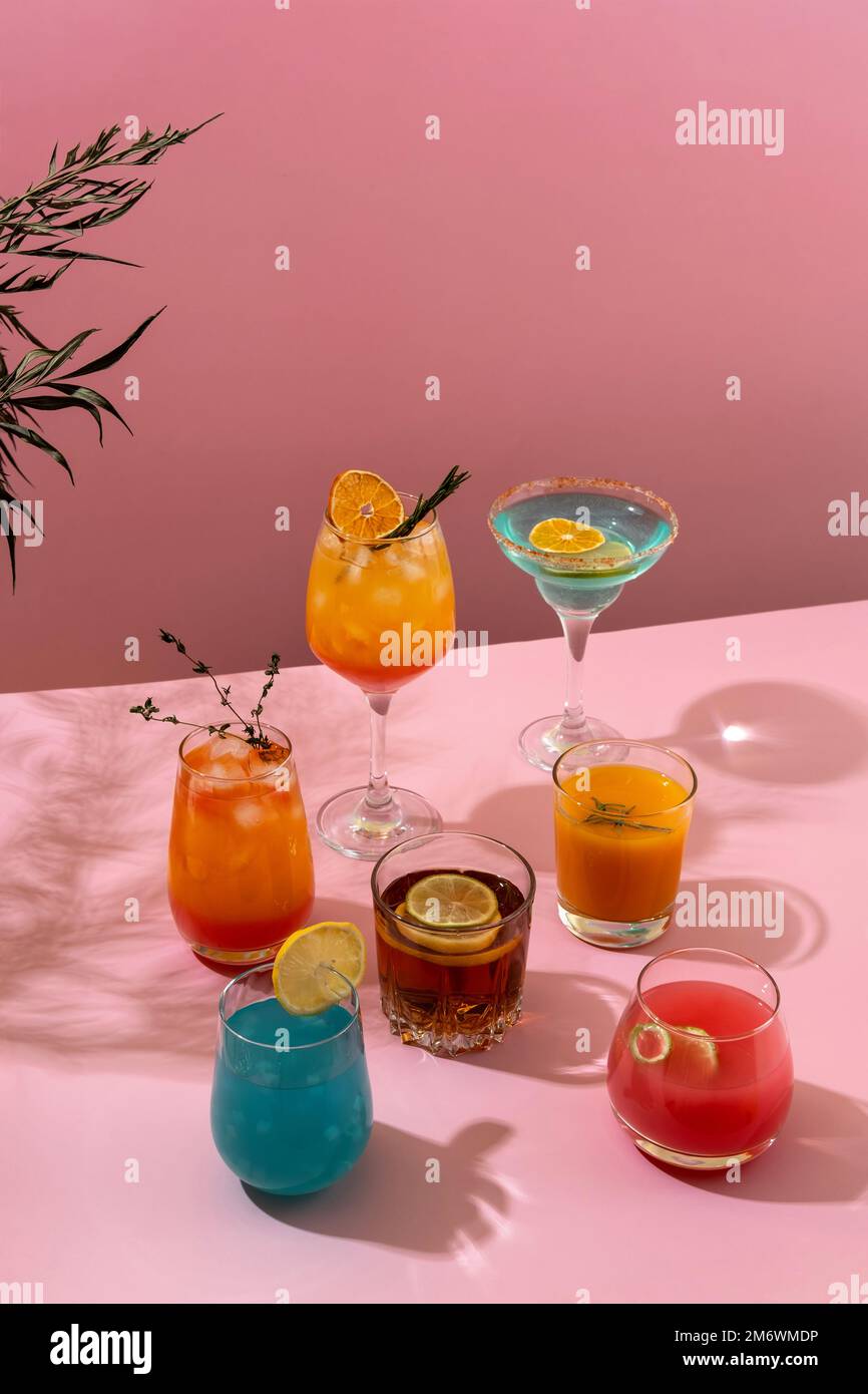 Colorful tropical cocktails. Refreshing colorful summer drinks on pink ...