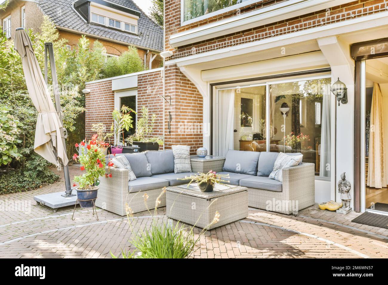 a patio with couches, tables and umbrellas on the side of the house ...