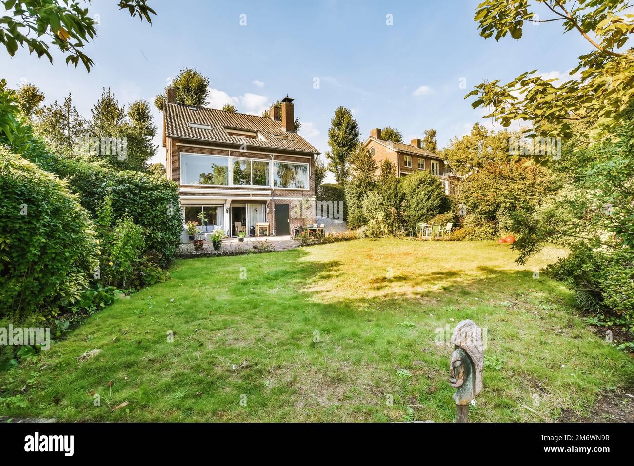 an outside view of a house with trees and bushes in the fore - image is ...
