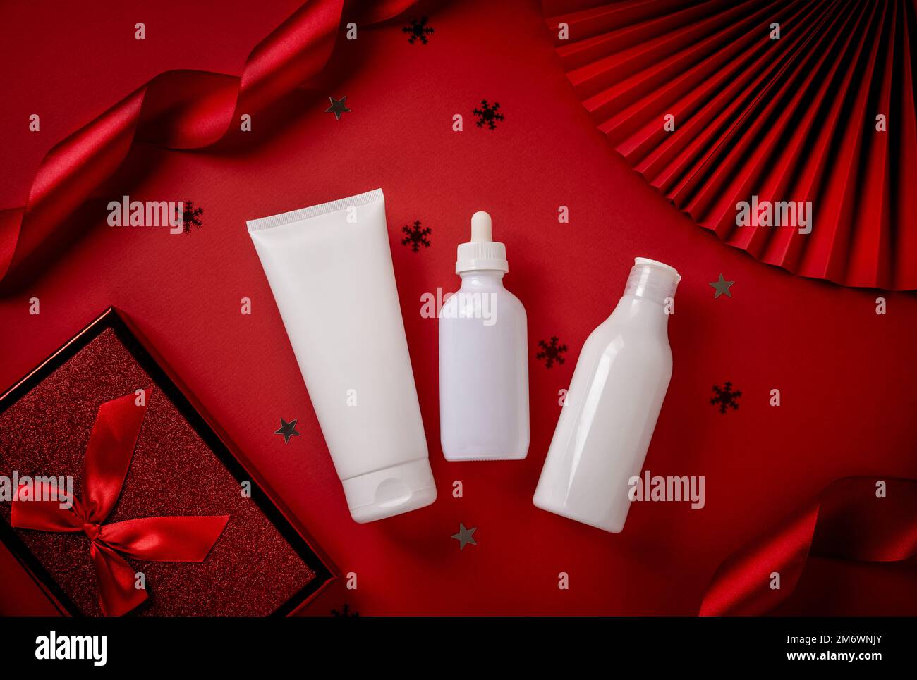White bottles cosmetic products with red ribbon and Christmas ...