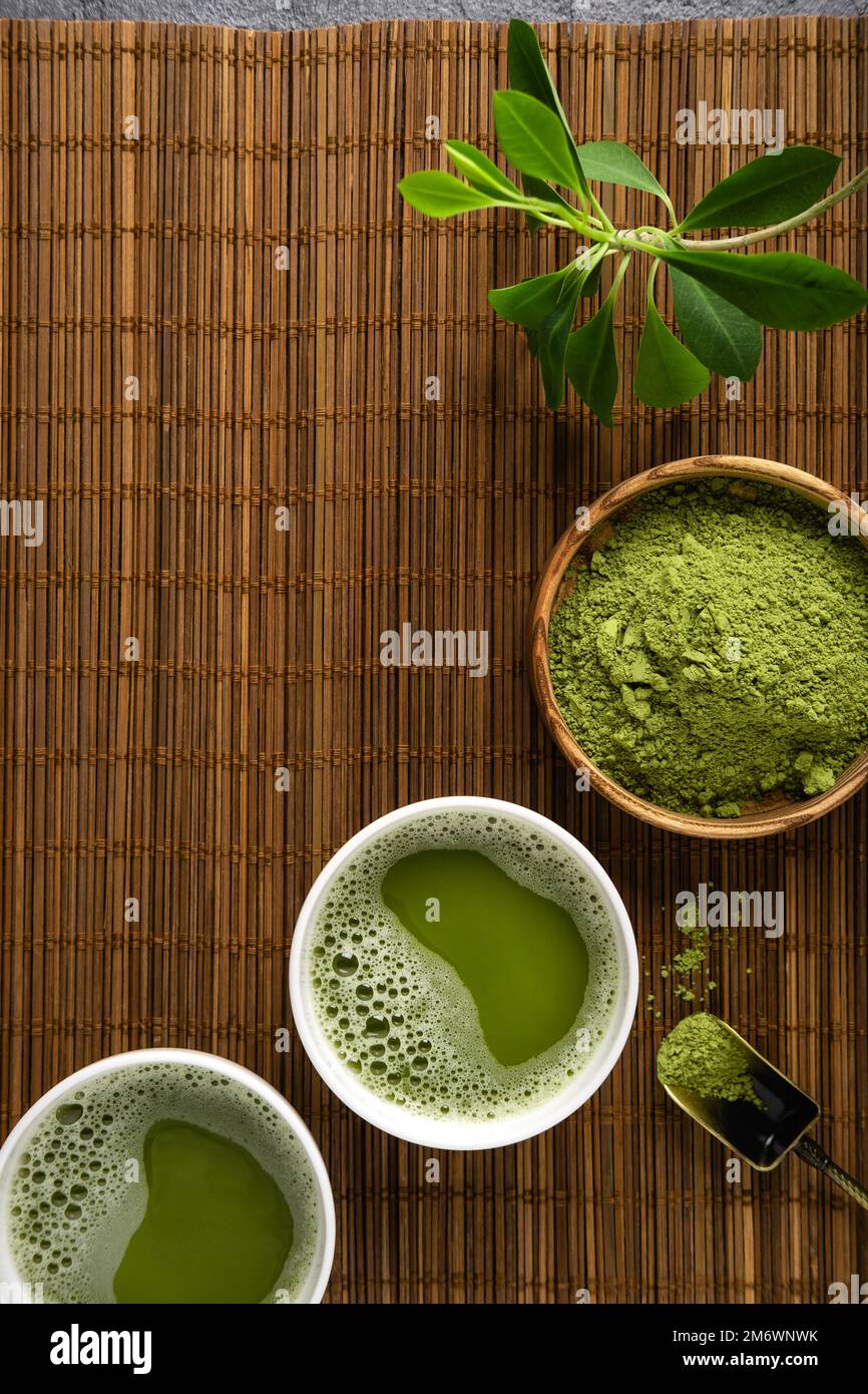 Matcha tea powder and tea accessories on bamboo napkin background. Tea ...