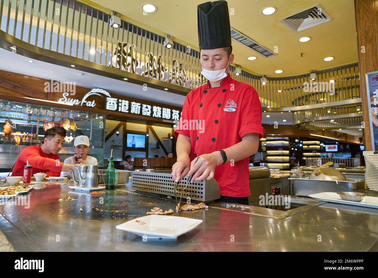 SHENZHEN, CHINA - CIRCA NOVEMBER, 2019: cook preparing food at ...