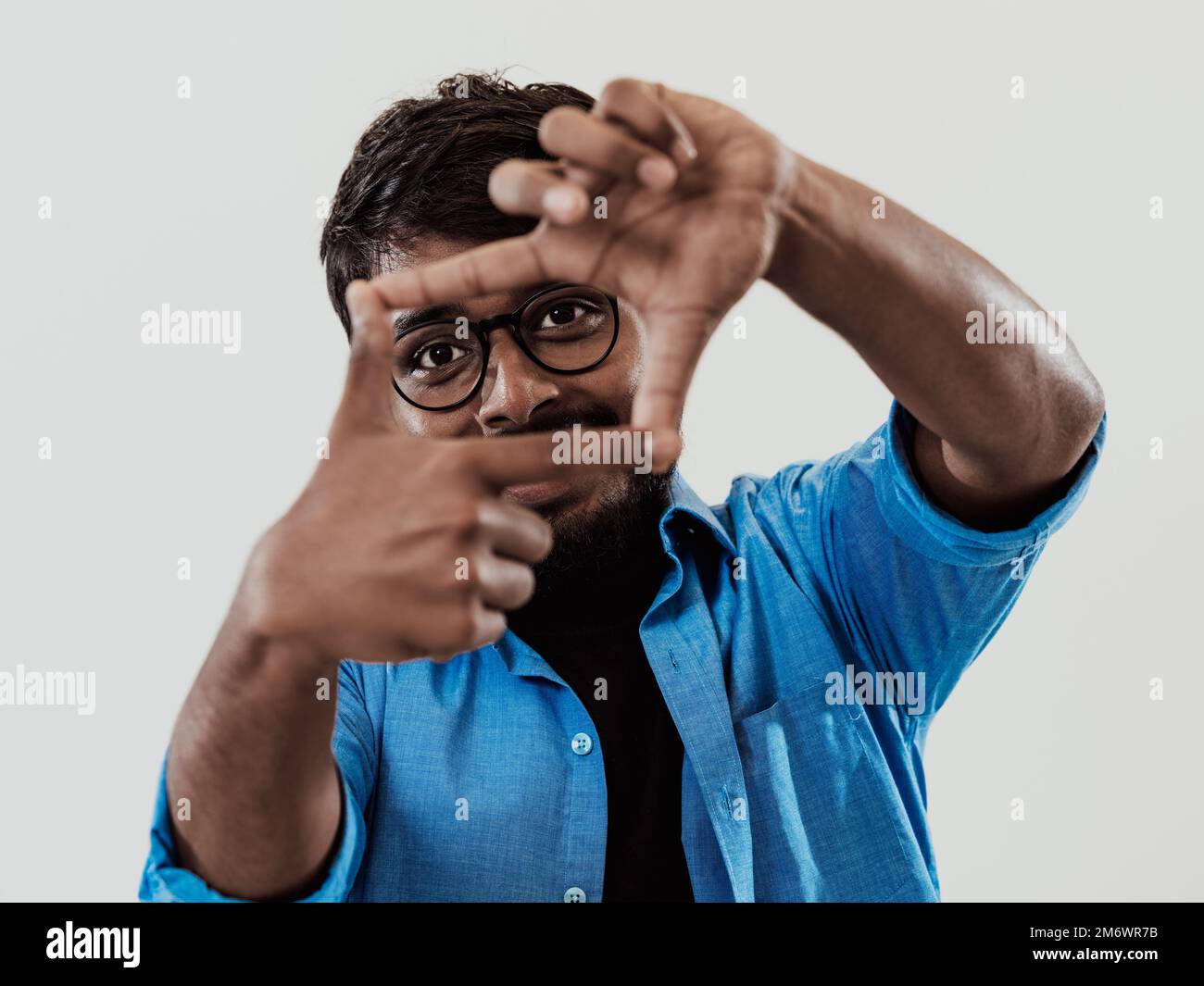 Young handsome man focusing with fingers, framing with hands isolated ...