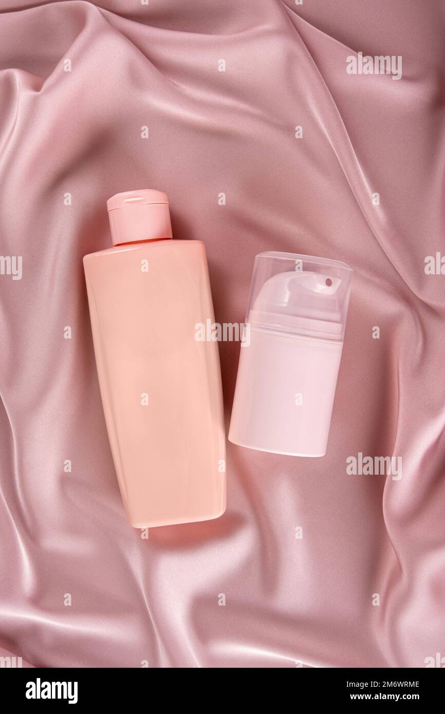Two bottle cosmetic product on pastel textile background. Beauty ...