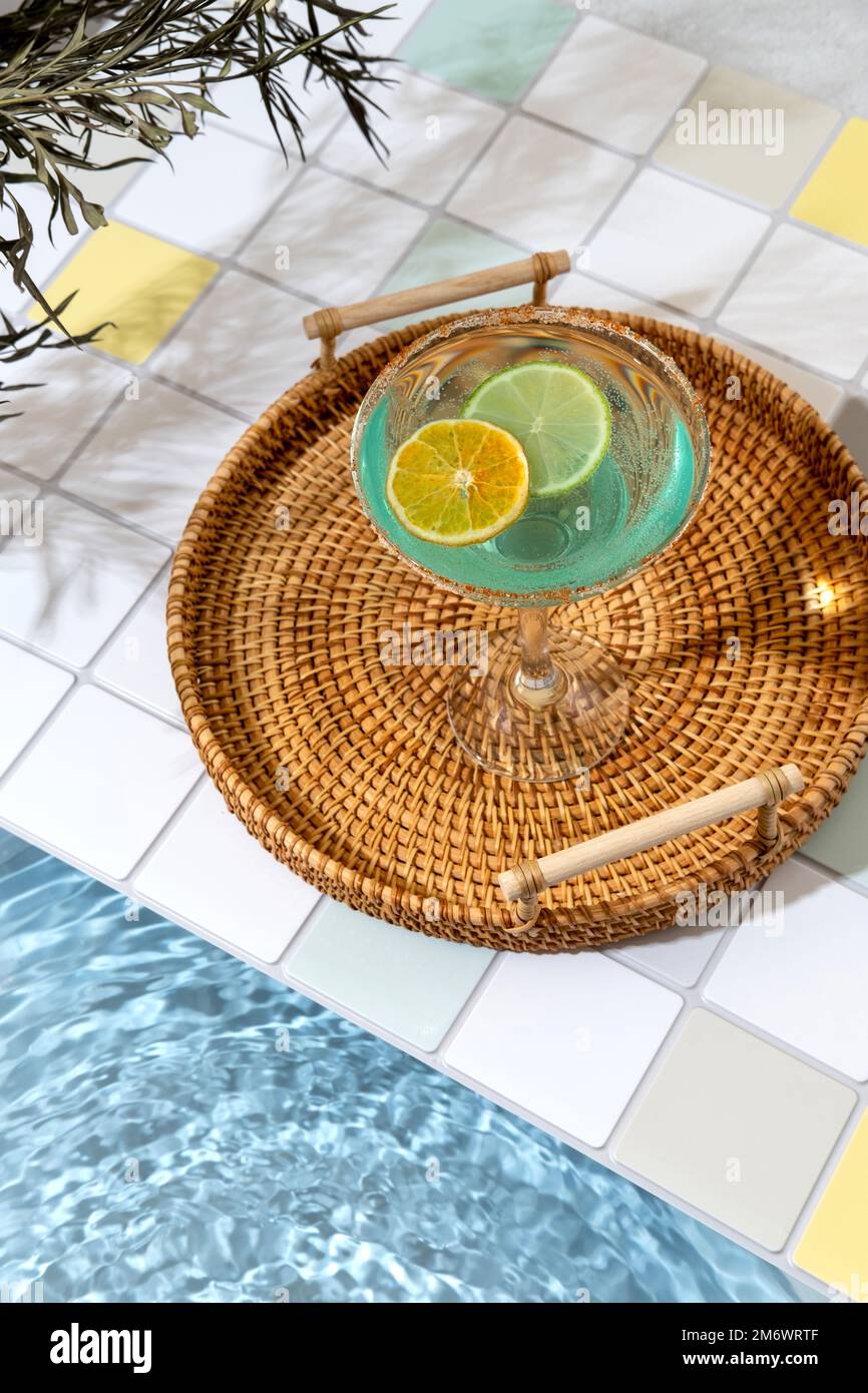Blue Lagoon cocktail on edge of swimming pool. Summer vacation and ...